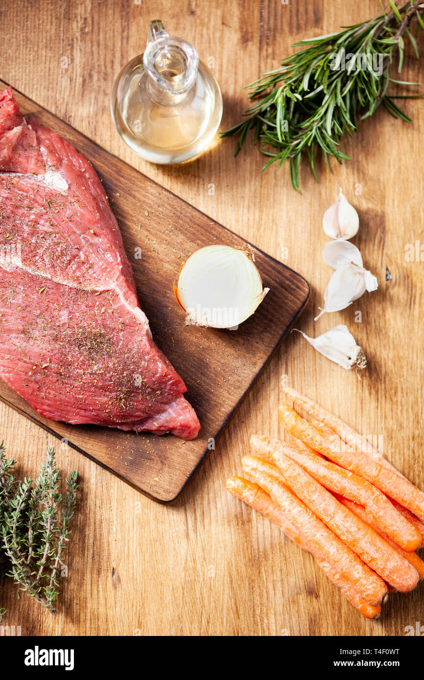 Raw steak with garlic and carrots on wooden background. Food ...