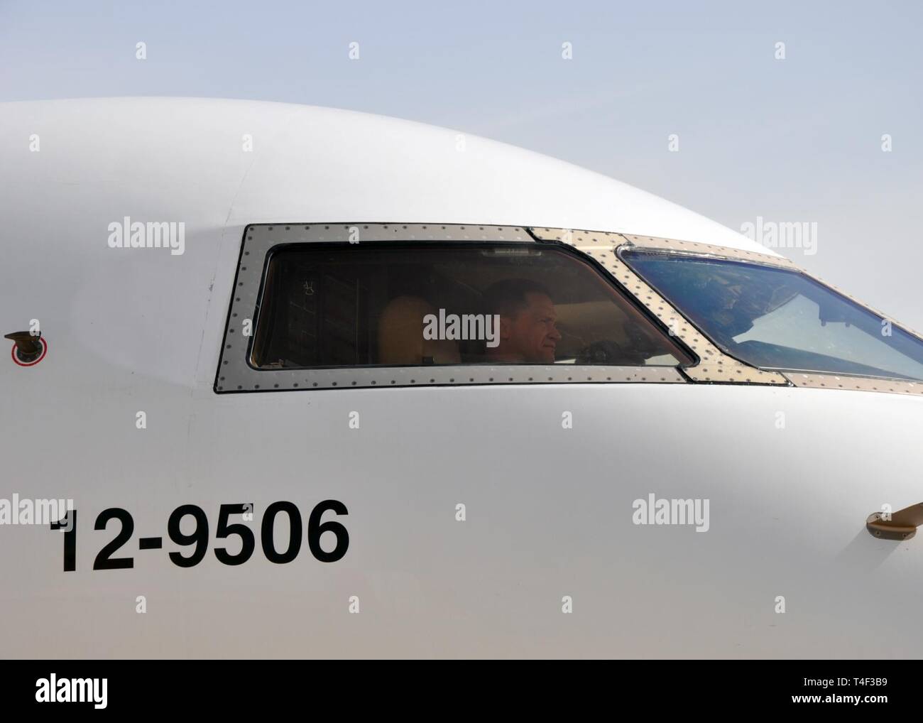 Two pilots run a pre-flight check on an E-11A aircraft outfitted with a ...
