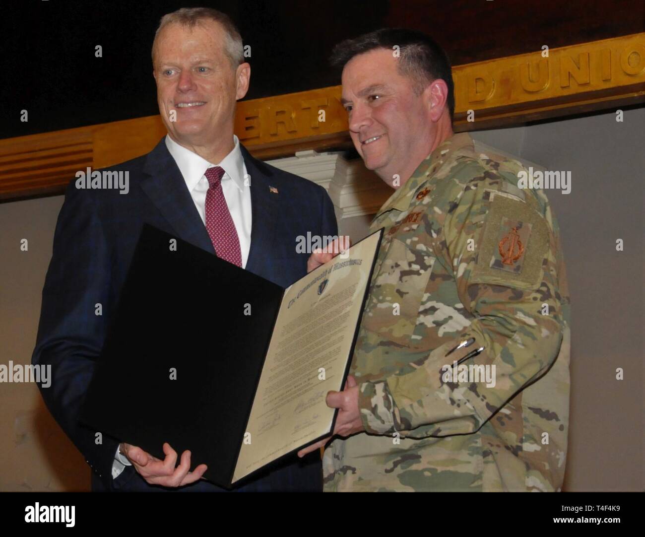 Massachusetts Governor Charlie Baker, left, presents a proclamation ...
