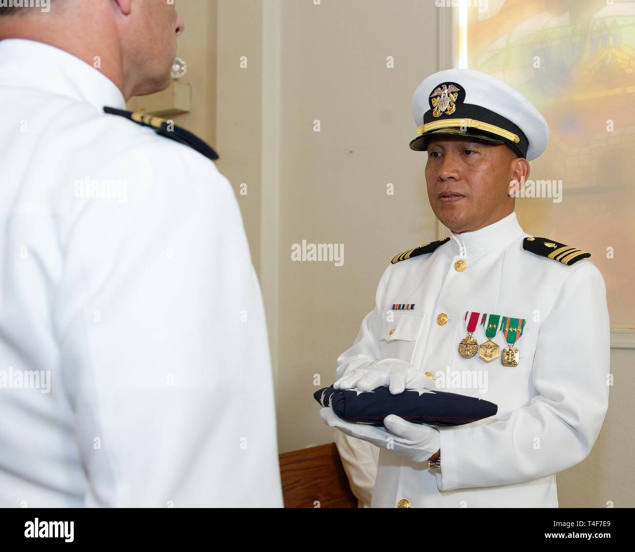 Lt. Cmdr. Felix Villanueva receives his flag from the Flag Detail ...