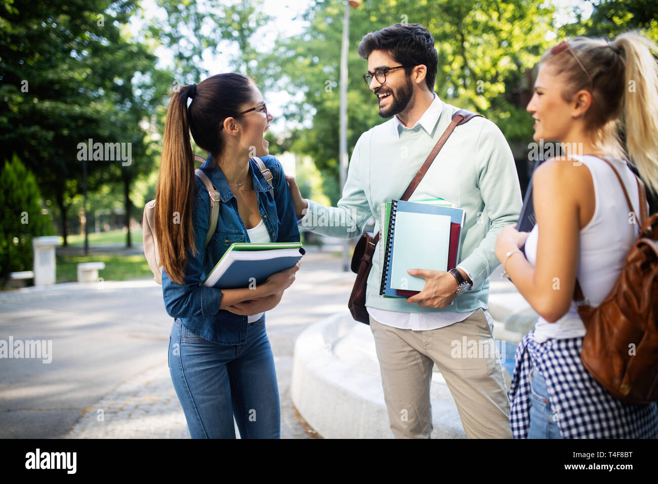 Happy young university students friends studying with books at ...