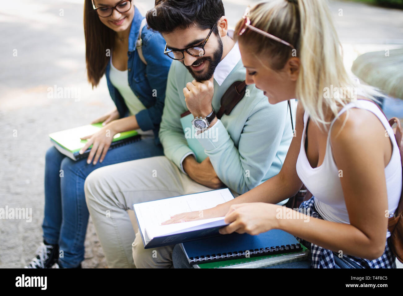 Happy university friends studying together in college Stock Photo - Alamy