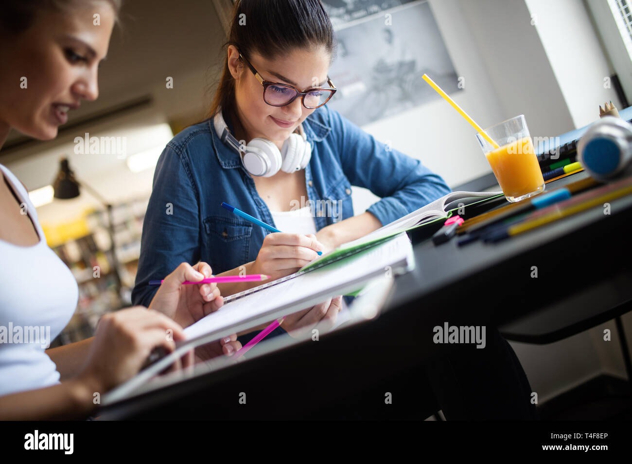 Happy university friends studying together in college Stock Photo - Alamy