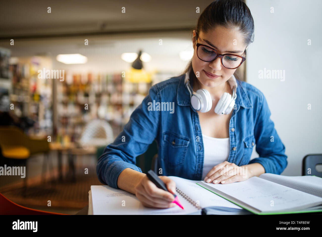 Beautiful student girl learning in a library Stock Photo - Alamy