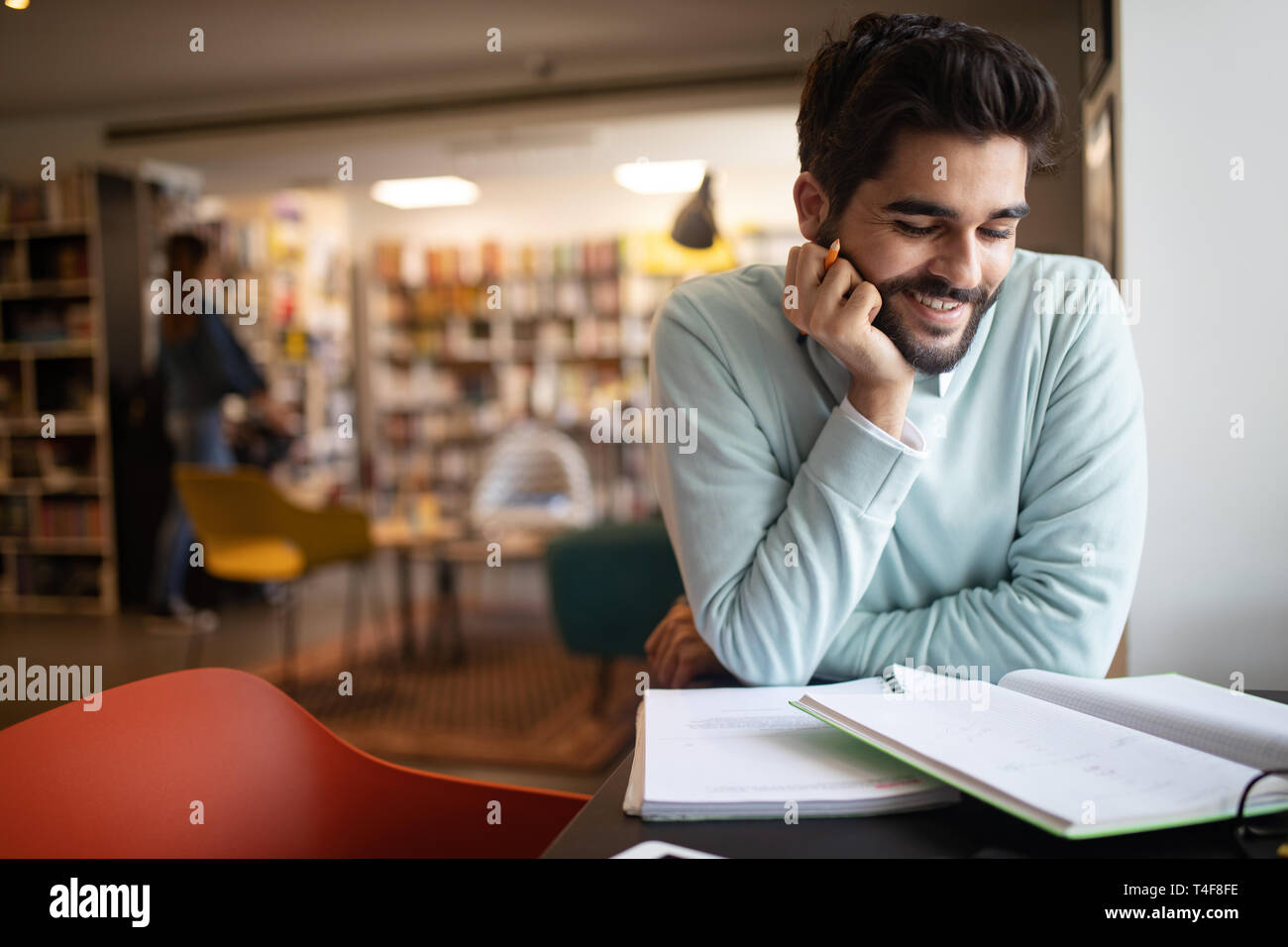 Happy student preparing exam and learning lessons in college library ...