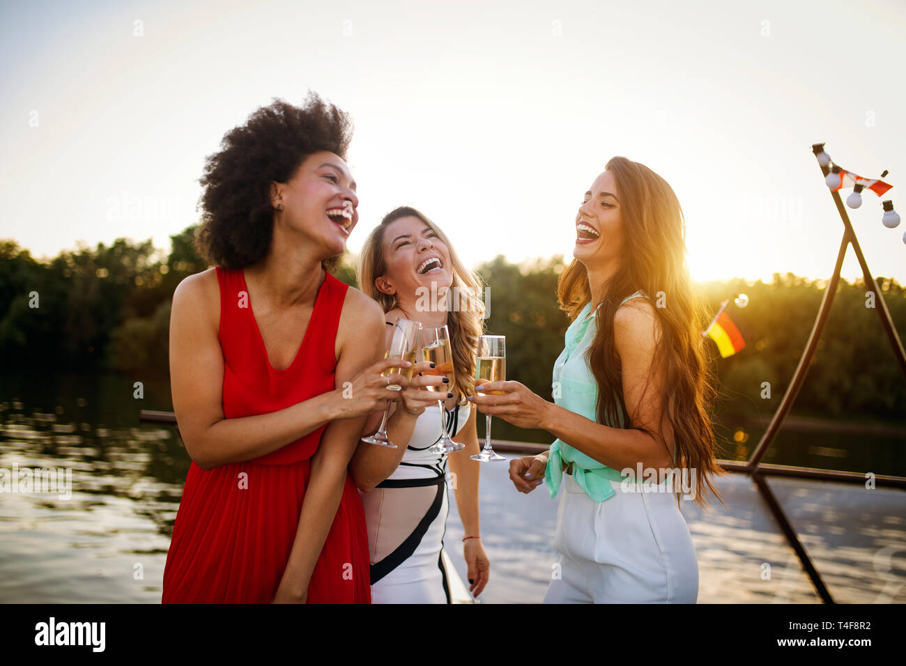 Group of friends drinking, chatting and having a fun at outdoor party ...