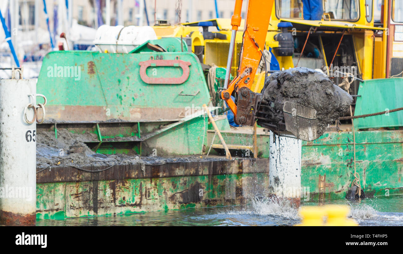 Excavator shovel digging in sand from water. Building construction ...