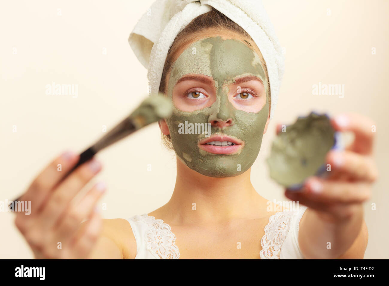 Skin care. Woman applying with brush clay mud mask to her face. Girl ...