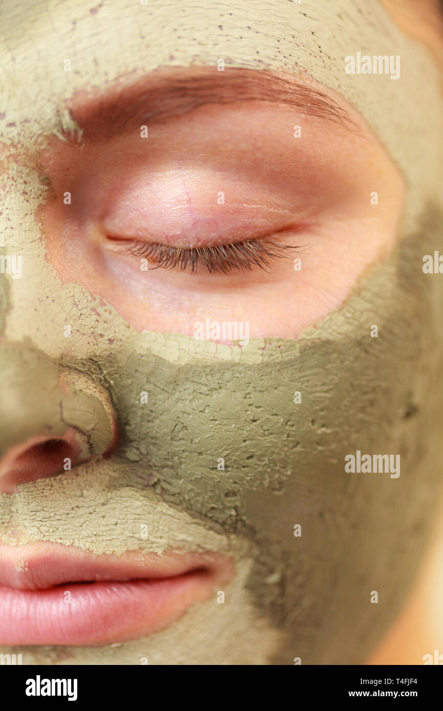 Skin care. Woman face with green clay mud mask close up. Girl taking ...