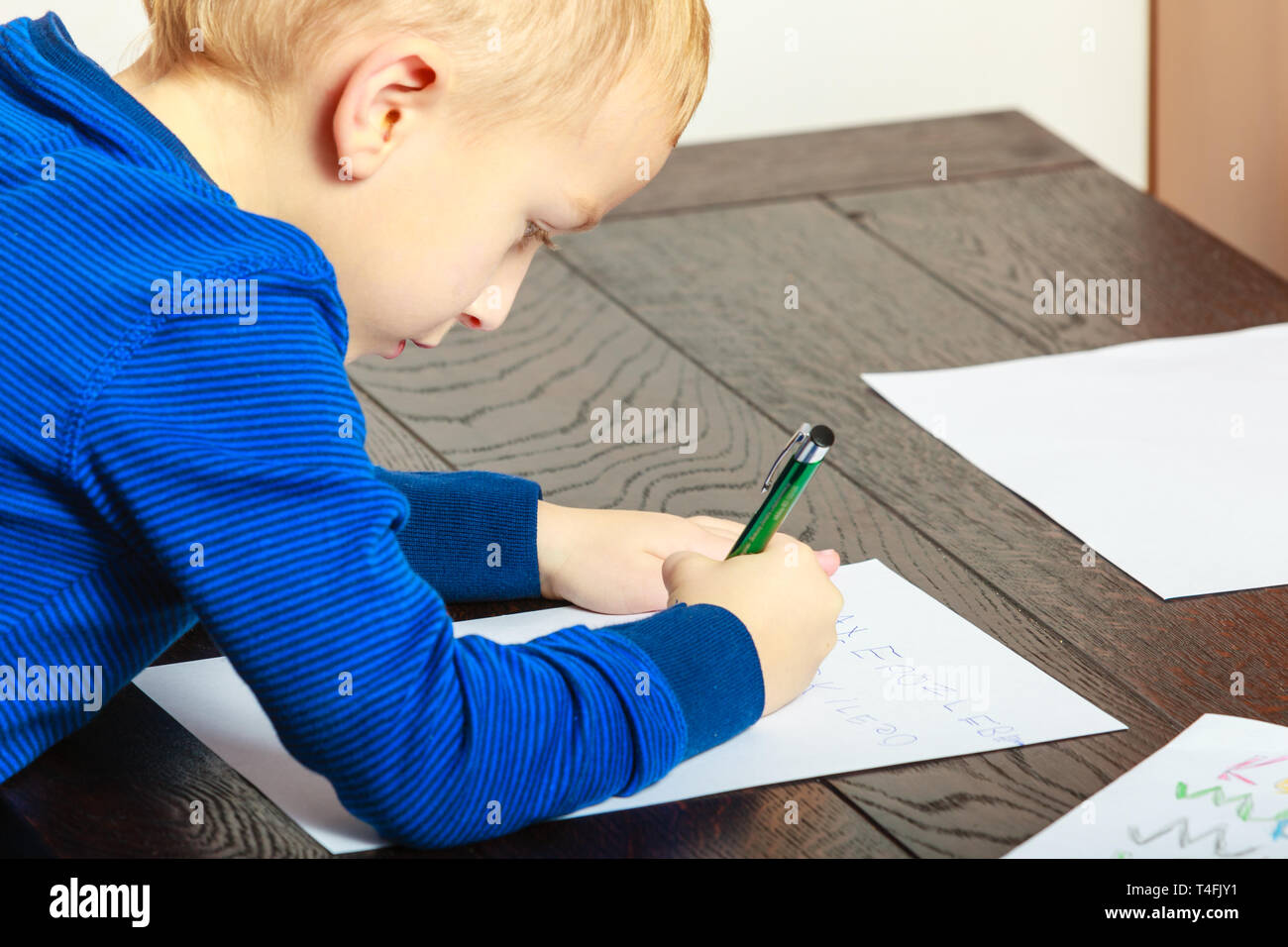Happy childhood. Blonde boy child kid with pen writing drawing on paper ...