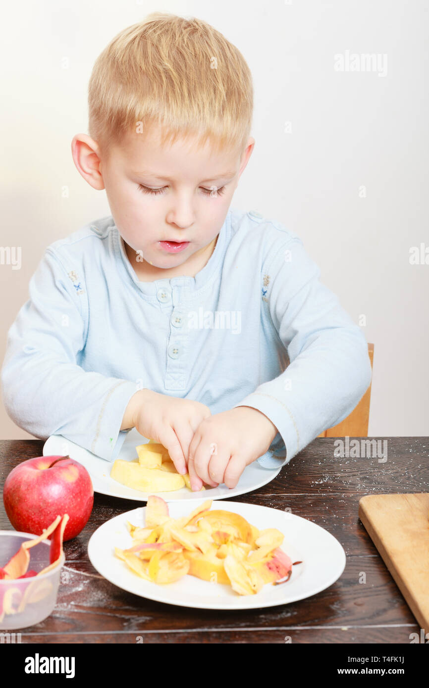 Happy childhood. Boy child kid preschooler eating peeled apple fruit or ...