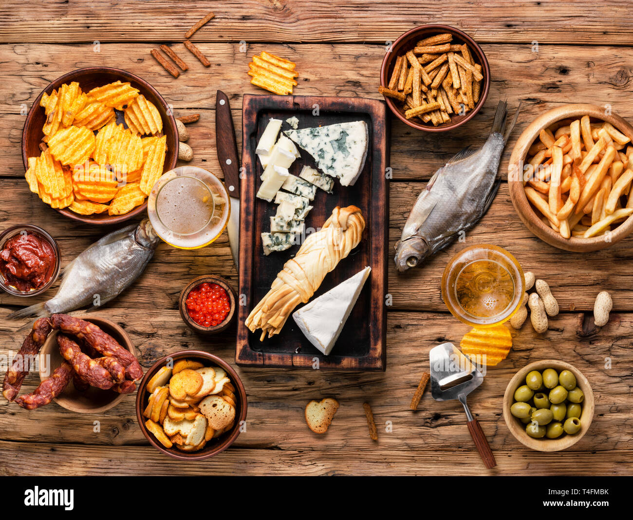 Large selection of snacks for beer. Set of cheeses, fish, chips and ...