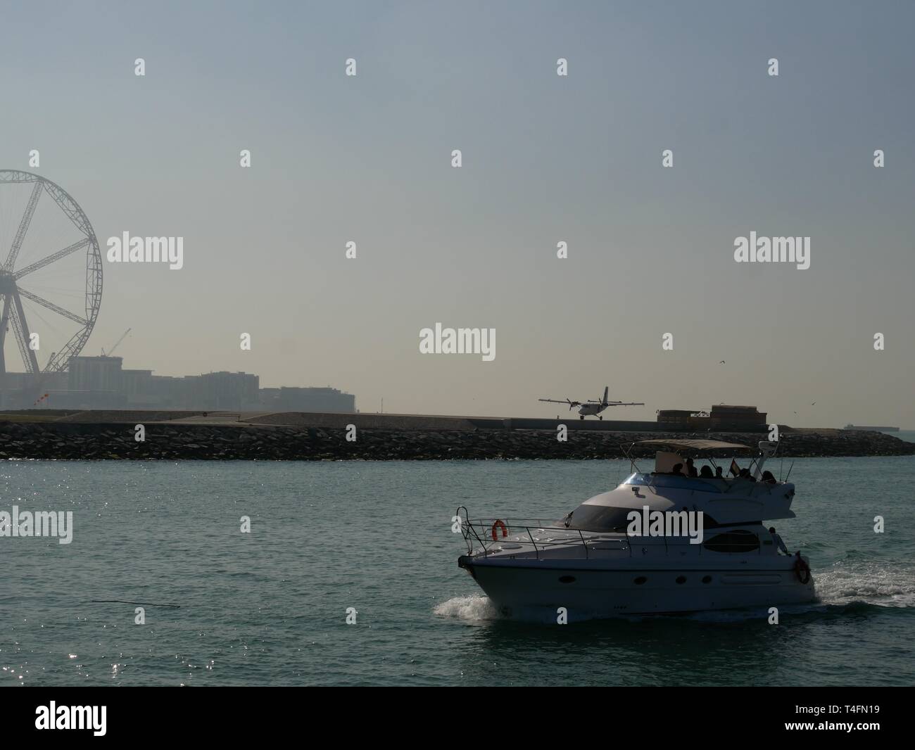 Boat heading for port with hangar and spike wheel in the background ...