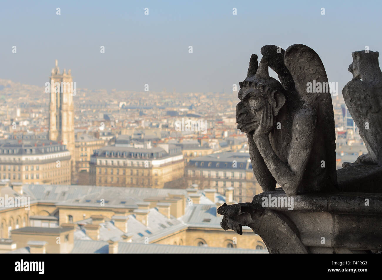 Gargoyle statue on notre dame and city skyline hi-res stock photography ...