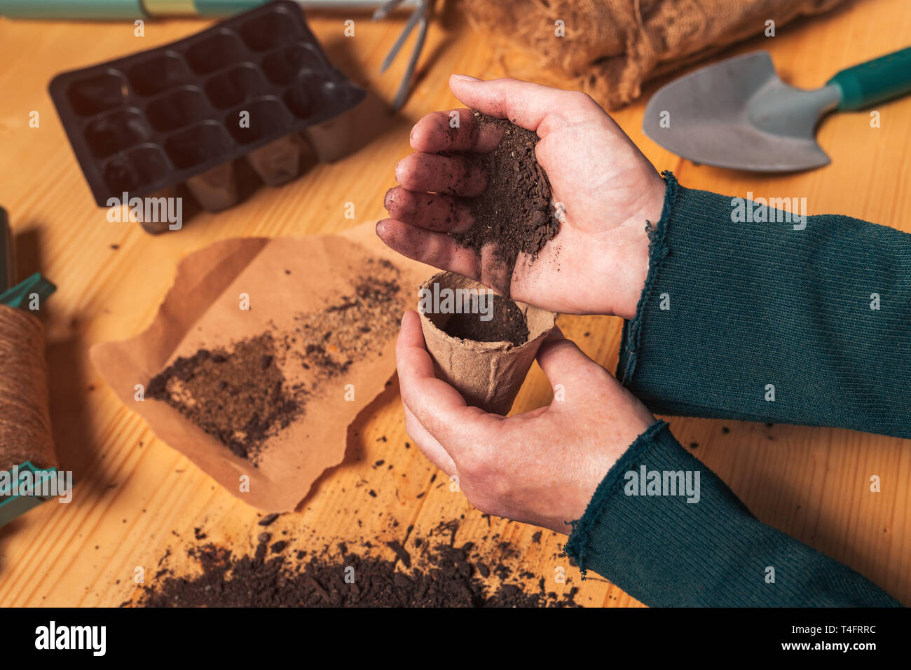 Gardener filling biodegradable soil pot container ready for sowing and ...