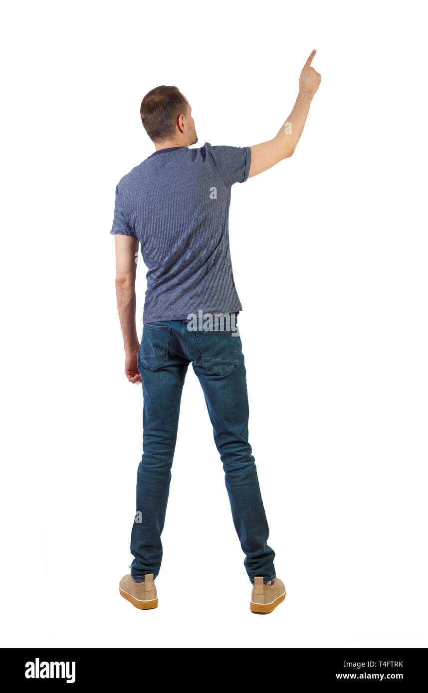Back view of a man in jeans points his hand upwards. Rear view people ...