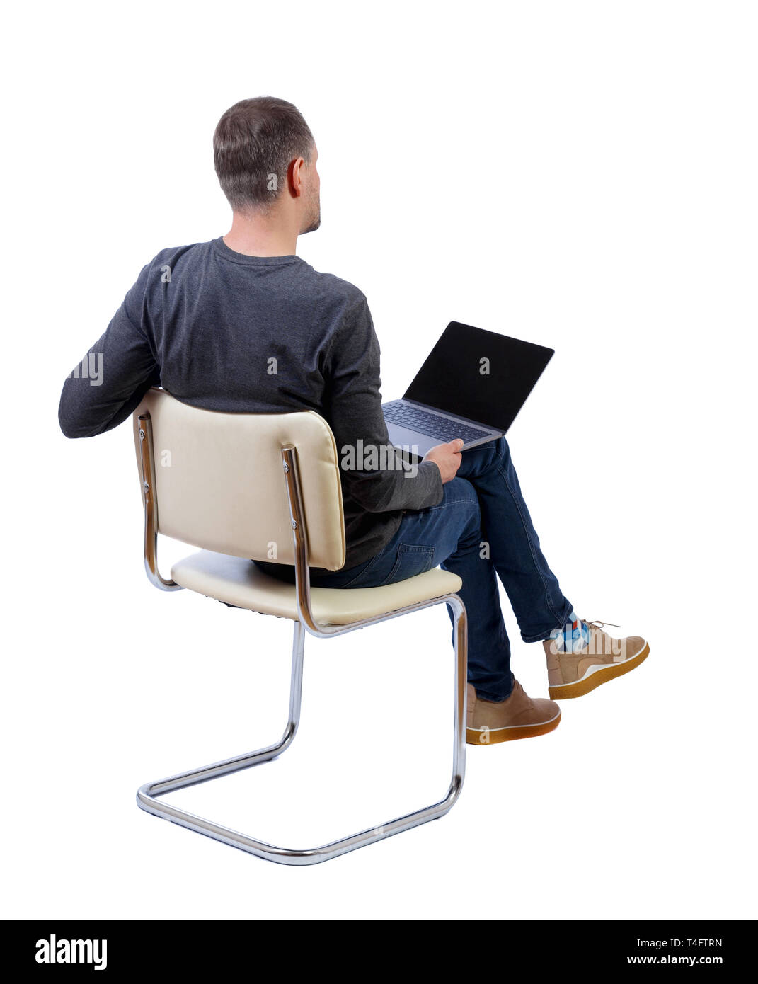 Back view of a man who sits on a chair with a laptop. Rear view people ...