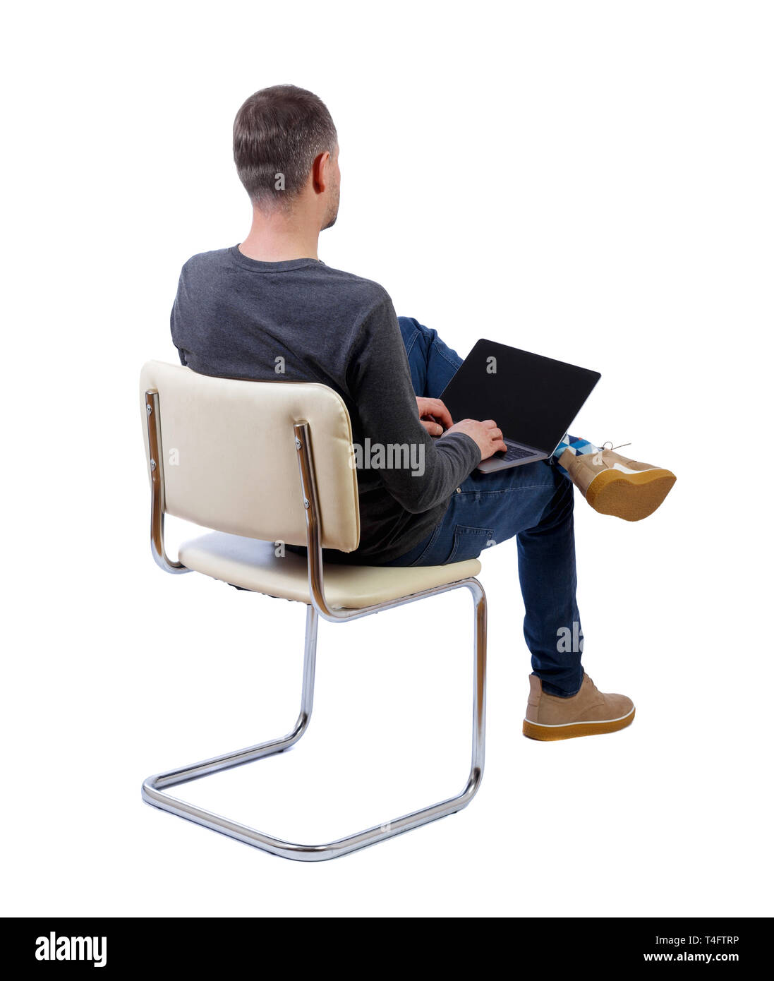 Back view of a man who sits on a chair with a laptop. Rear view people ...