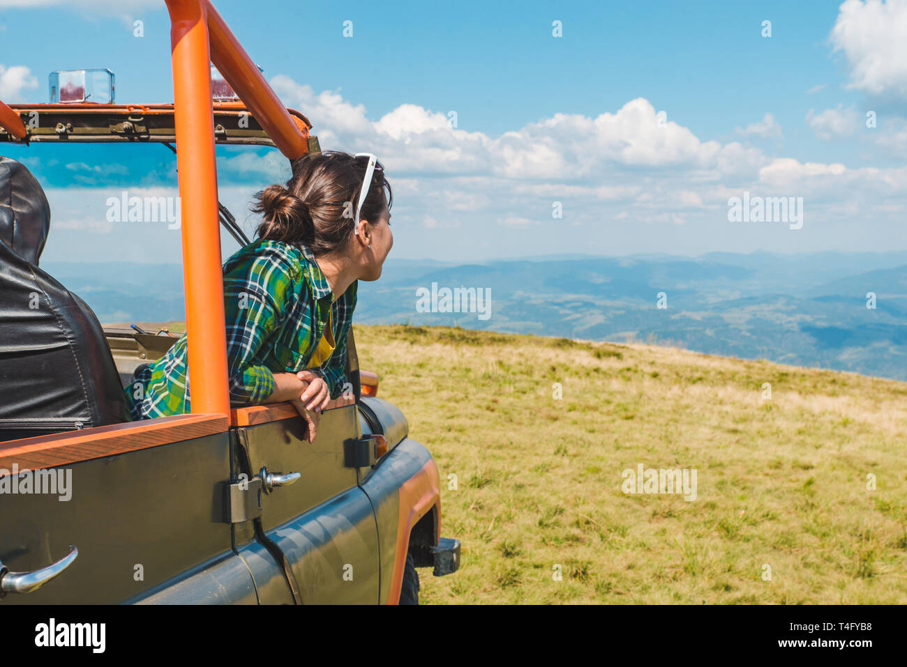 woman in off road cur at the top of the mountain. beautiful view on ...