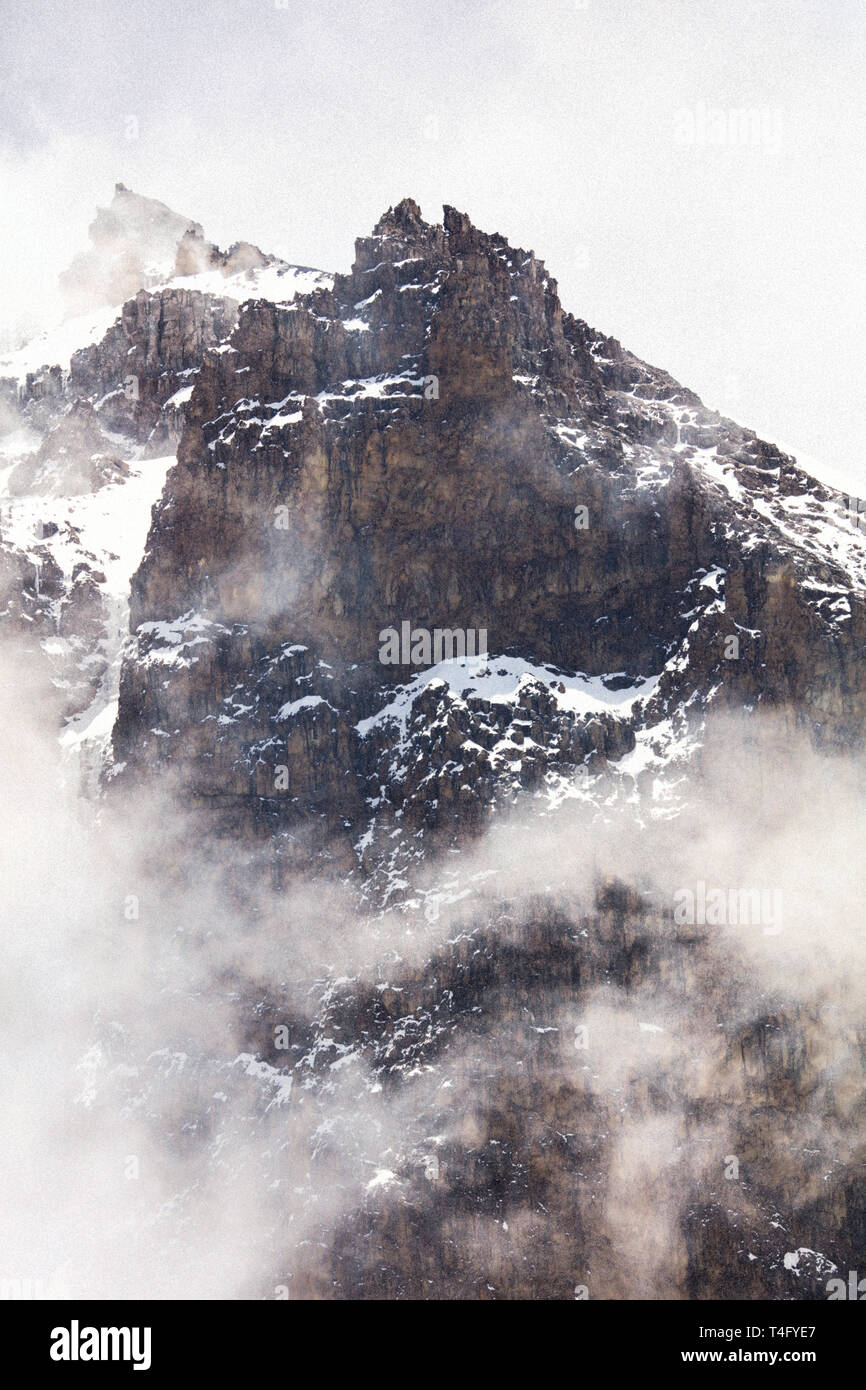 Powerful black mountain with high dangerous peaks, covered with snow ...