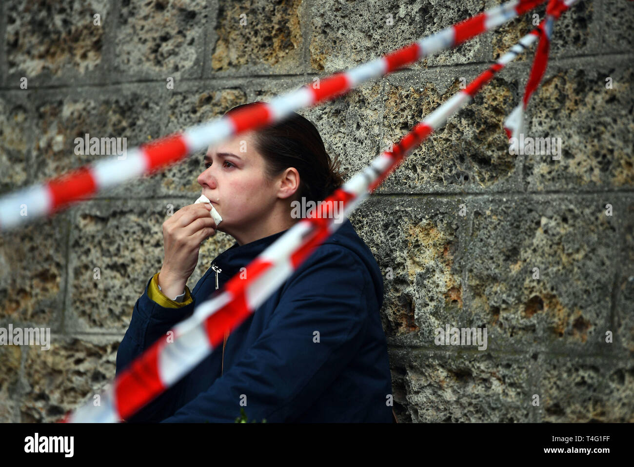 An onlooker wipes away a tear at a police cordon line near the Notre ...