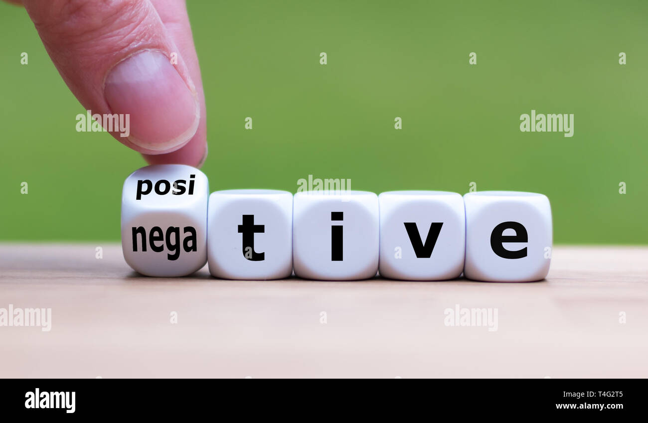 Hand turns a dice and changes the expression "negative" to "positive ...