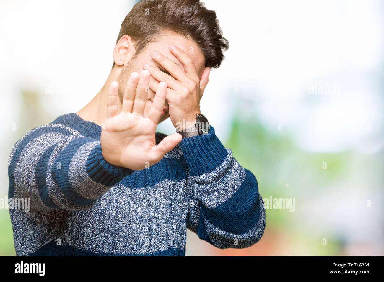 Young handsome man over isolated background covering eyes with hands ...