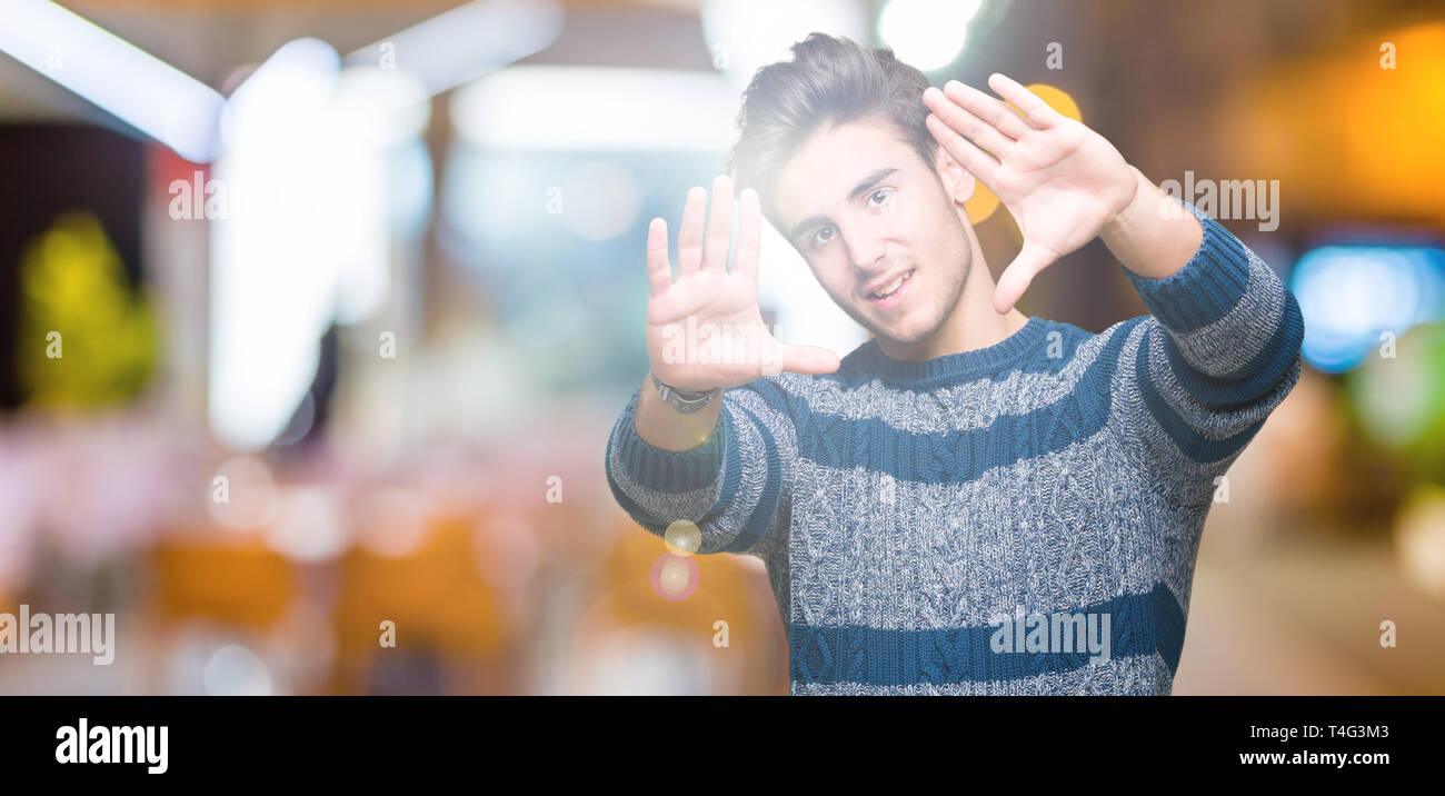 Young handsome man over isolated background Smiling doing frame using ...