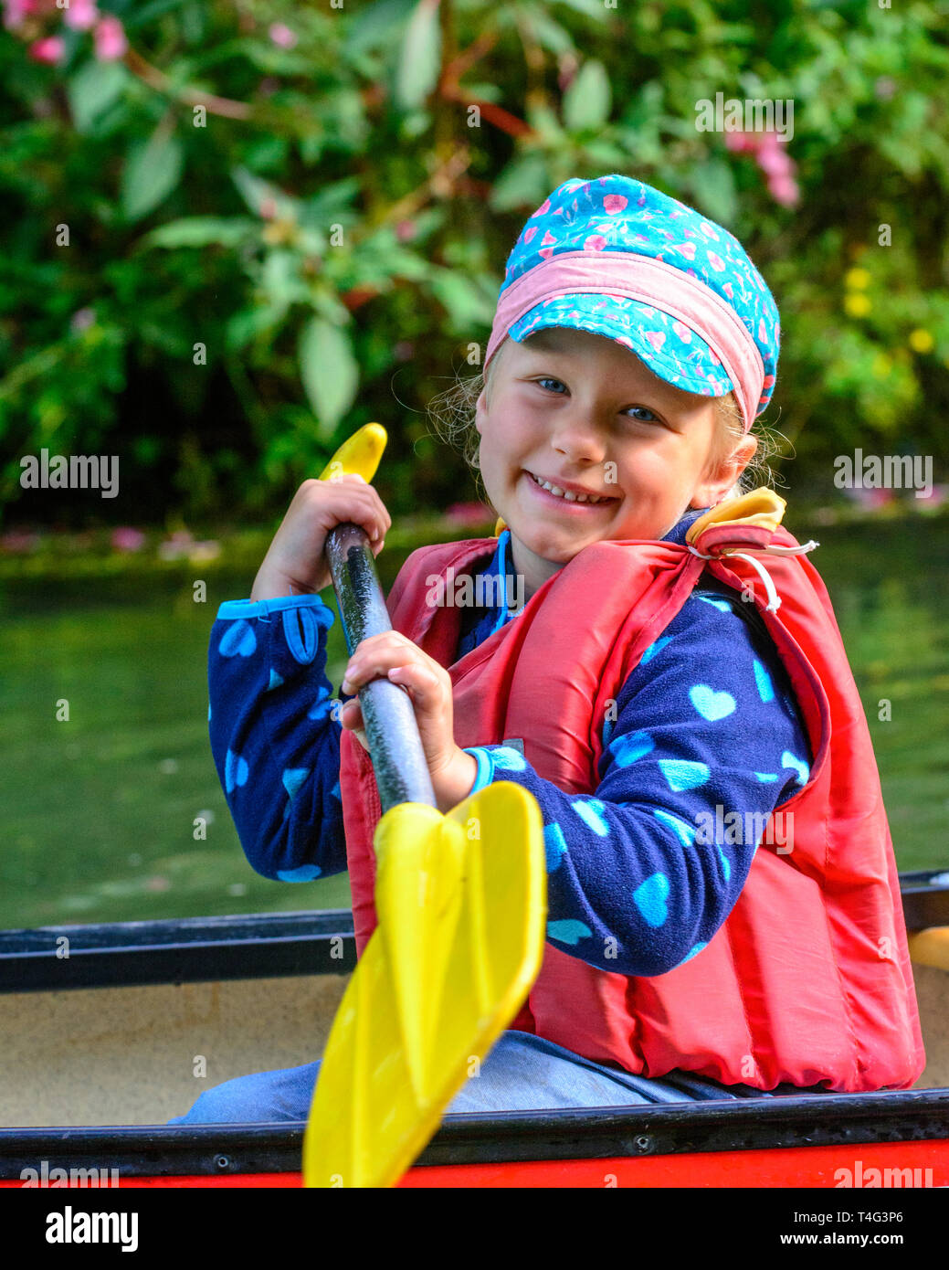 Cheeky little girl has fun while paddling in canoe Stock Photo - Alamy