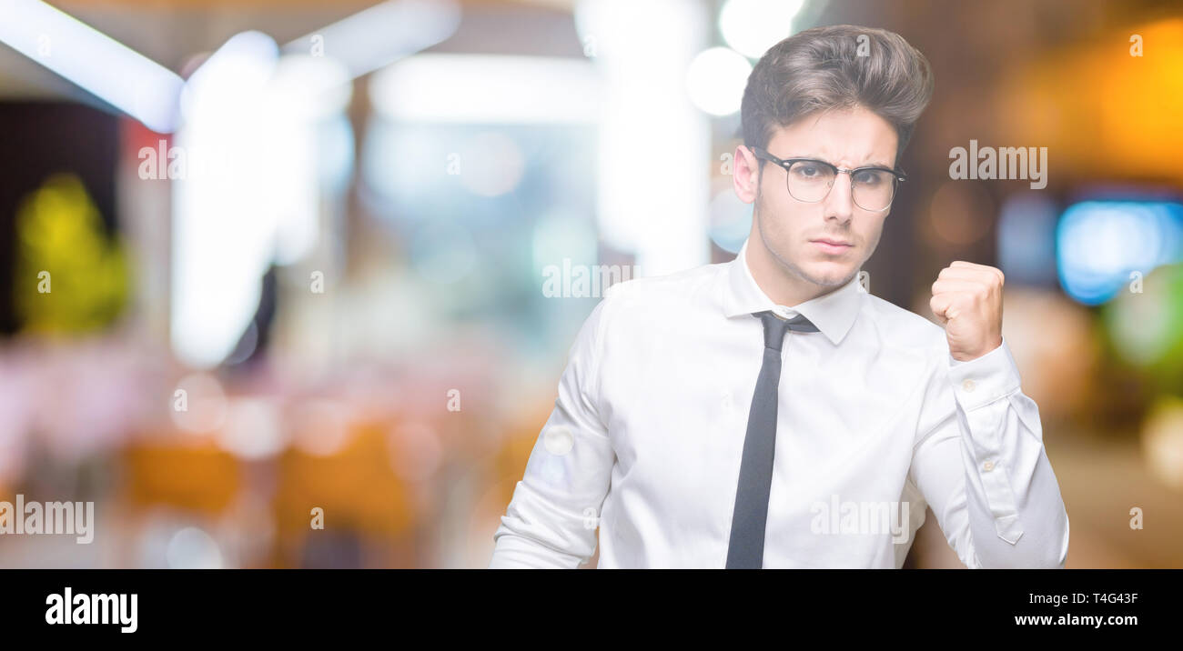 Young business man wearing glasses over isolated background angry and ...