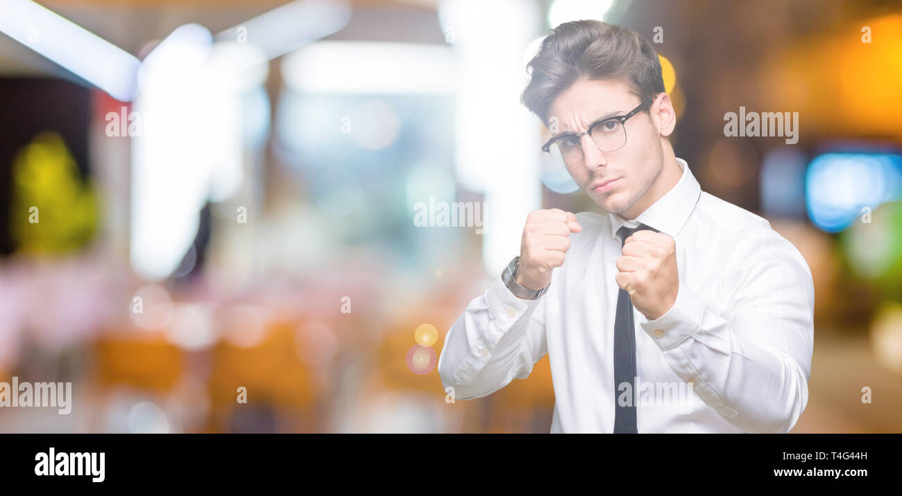 Young business man wearing glasses over isolated background Ready to ...