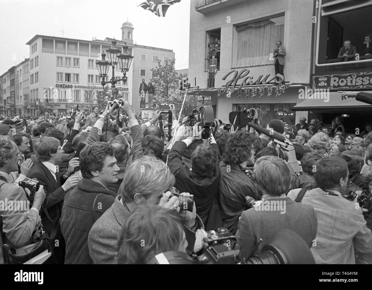 Queen Elizabeth is covered by the crowd of people while walking on the ...