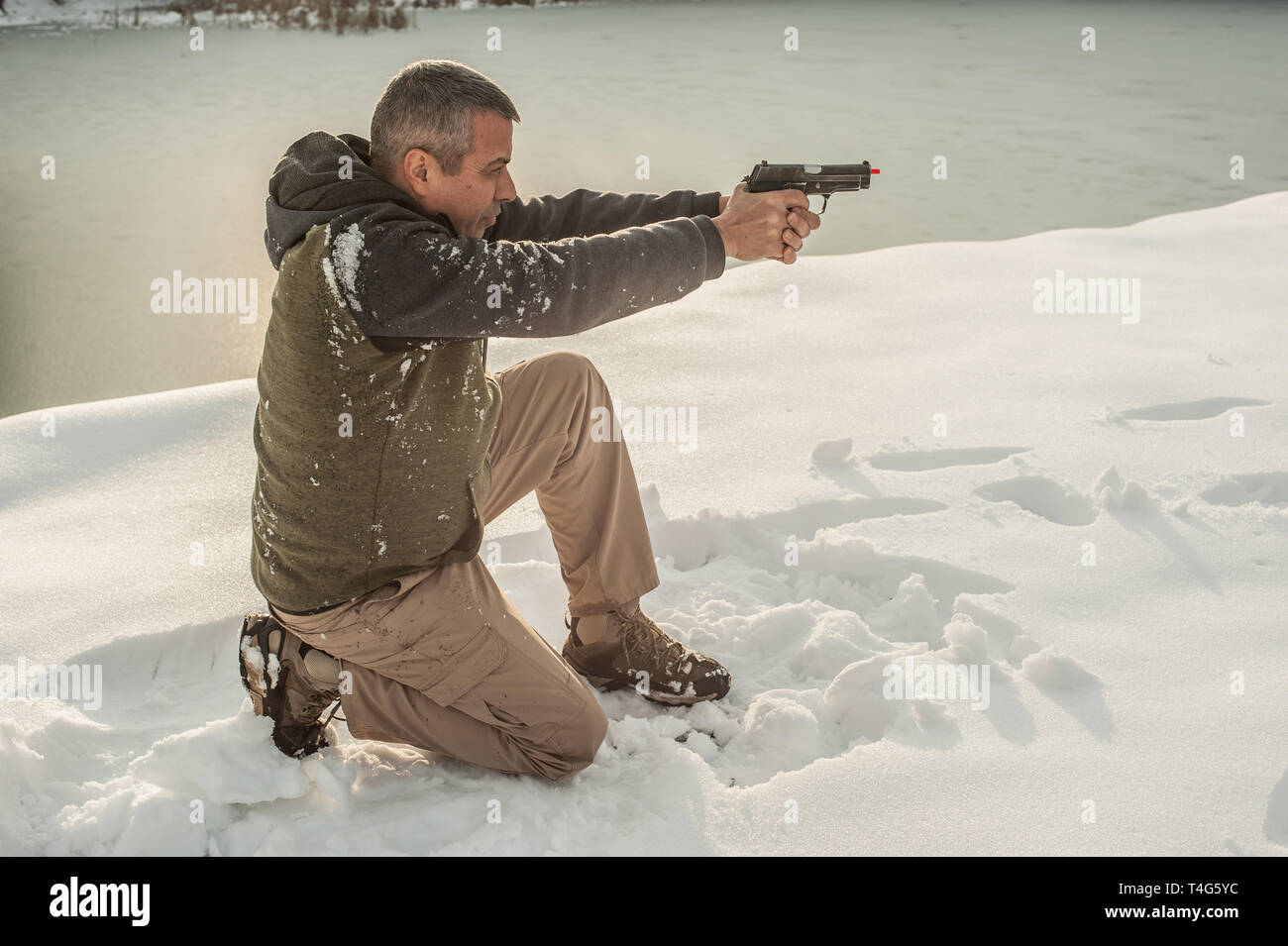 Instructor demonstrate body position of combat gun shooting at winter ...