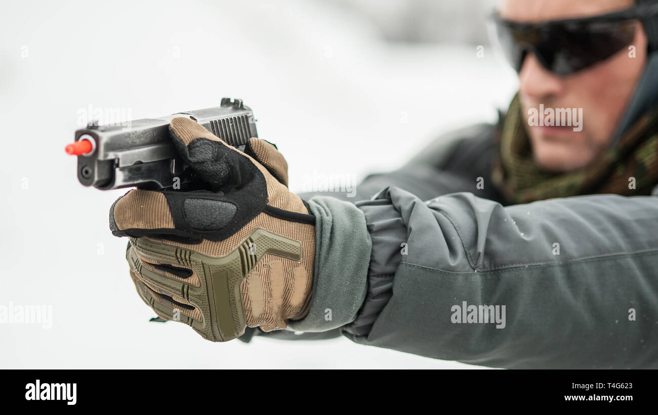 Close-up detail view of shooter hands holding gun with safety stick ...