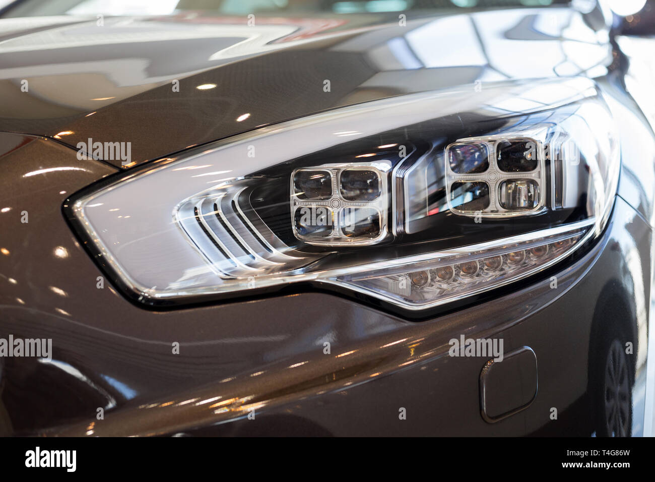 New modern car with elegant quadrate head lamps. Front view. Close up ...