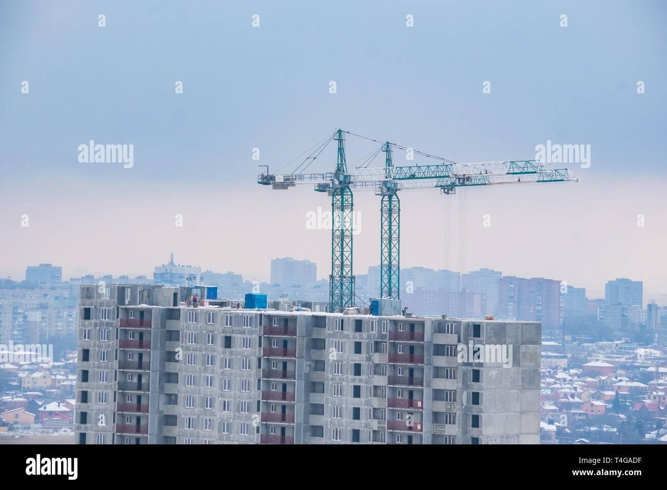 Construction of the new building. Two cranes in winter Stock Photo - Alamy