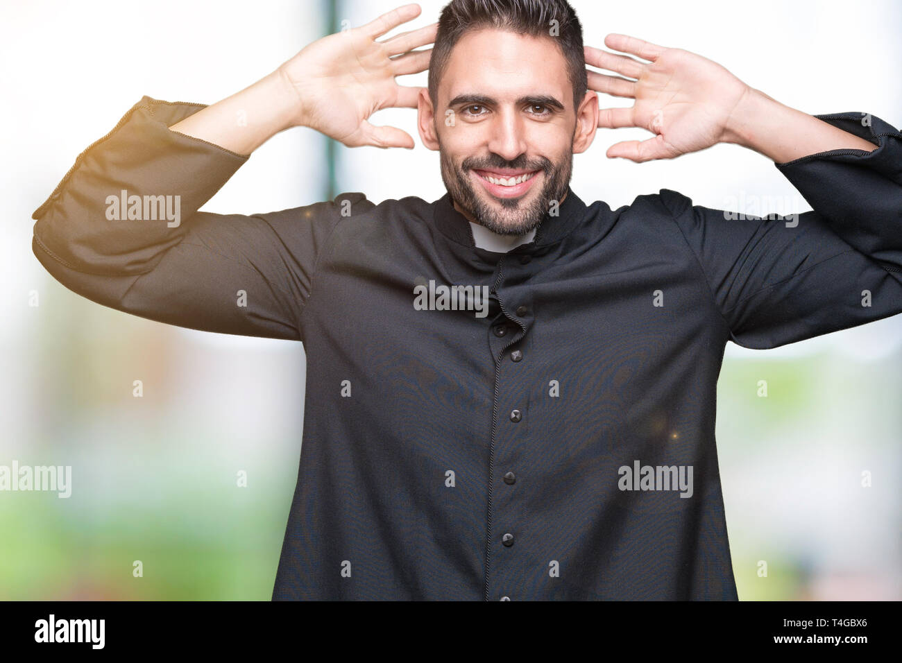 Young Christian priest over isolated background Relaxing and stretching ...
