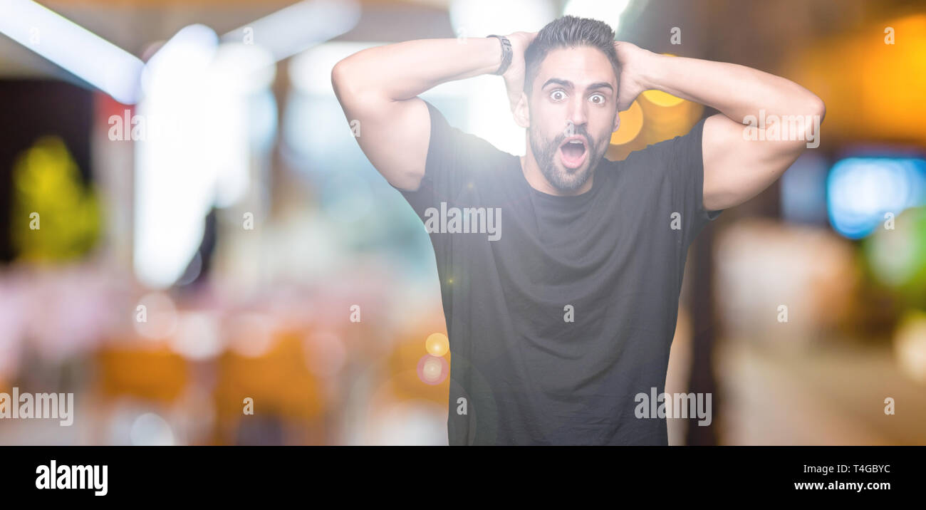 Young handsome man over isolated background Crazy and scared with hands ...