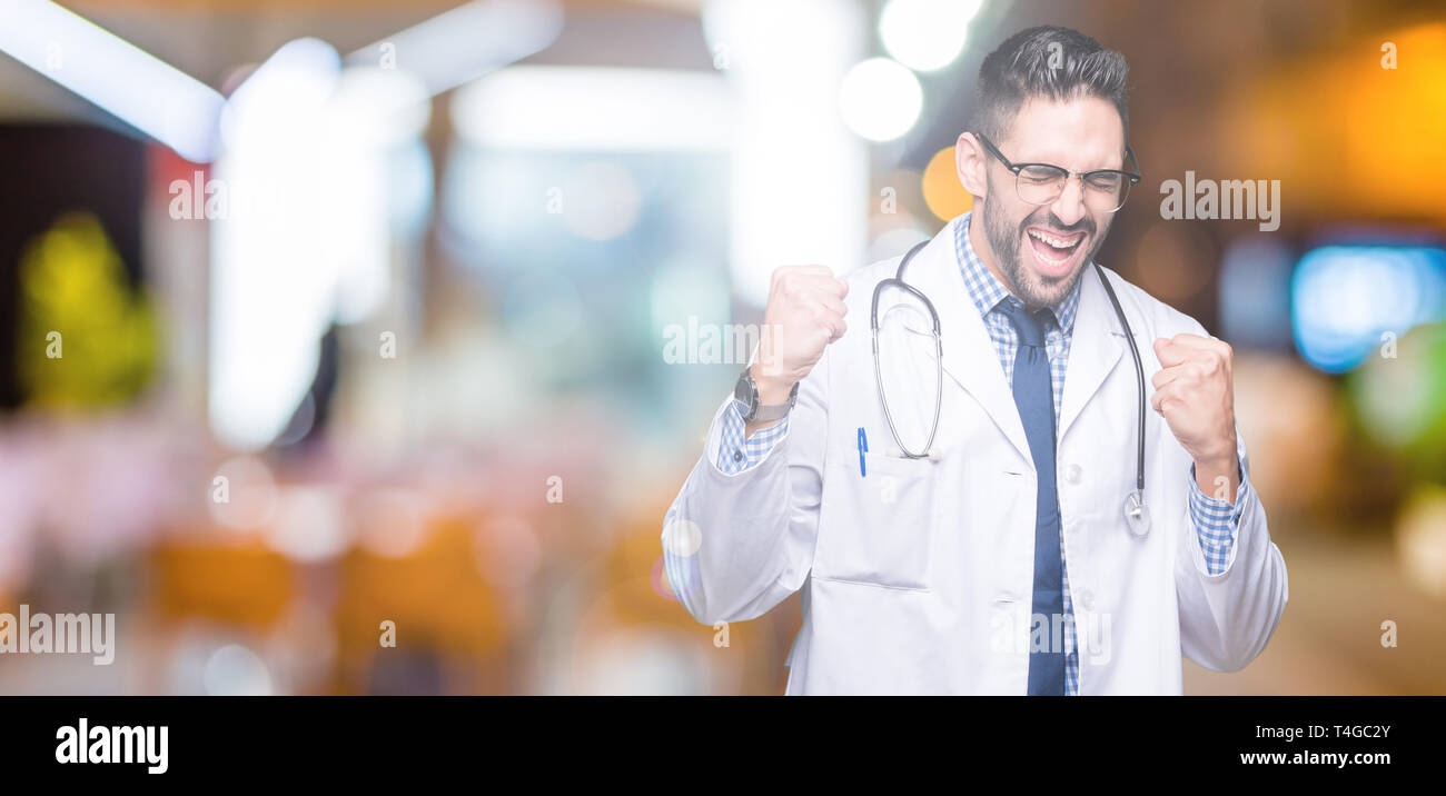 Handsome young doctor man over isolated background very happy and ...