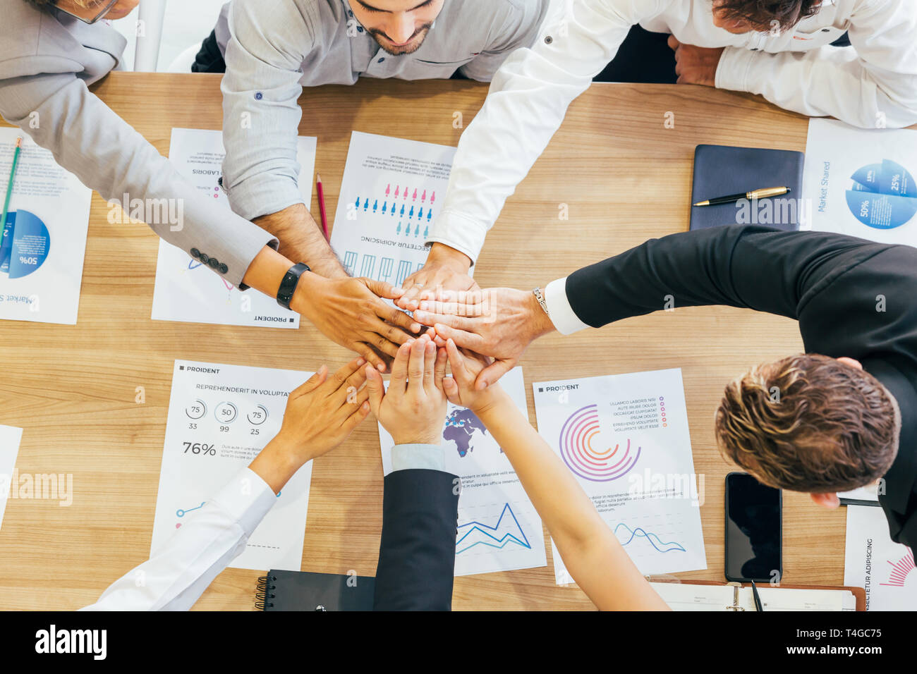 Crop coworking business people stacking hands above wooden desk with ...