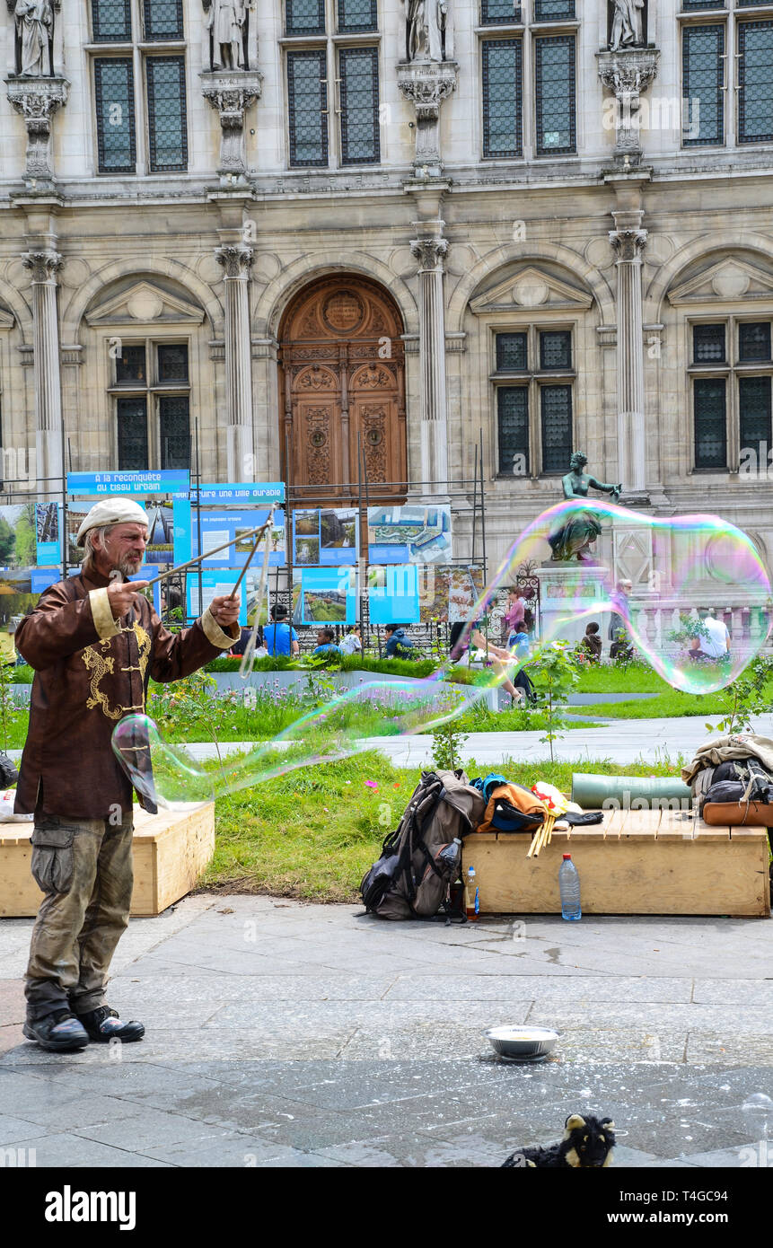 Street entertainer blowing huge bubble outside Hotel de Ville, Neo ...