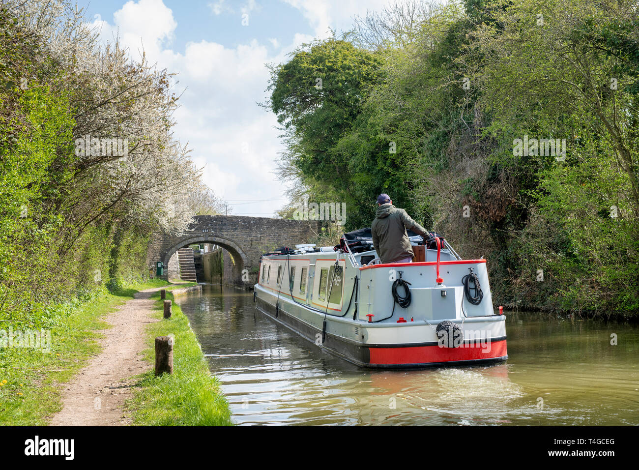Canal boat heading towards a bridge and lock on the oxford canal on a ...