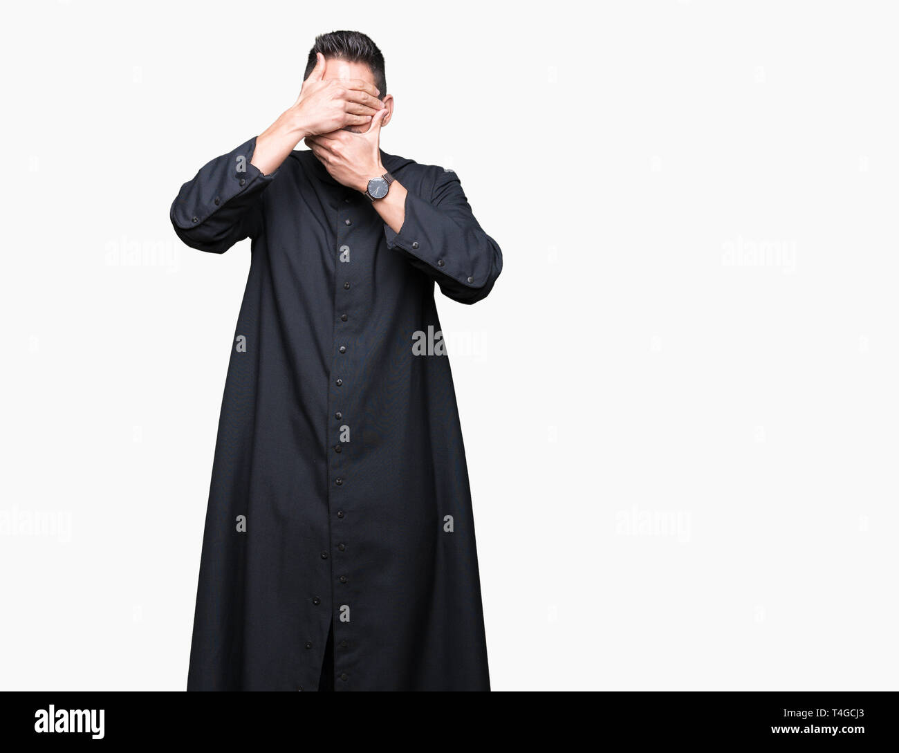 Young Christian priest over isolated background Covering eyes and mouth ...