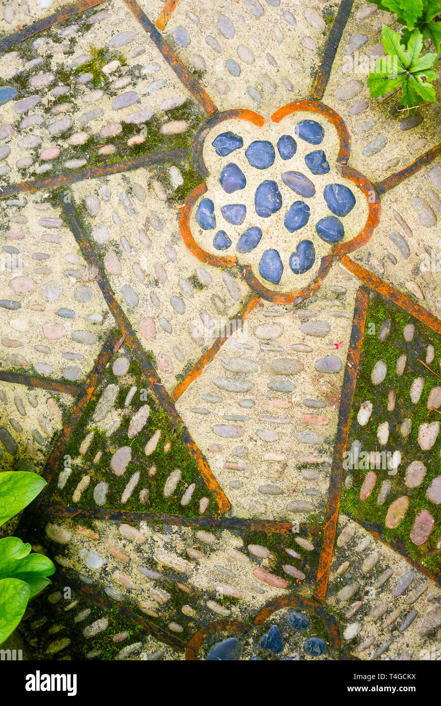 Ornate assembly of stones and tiles to form an original paved area and ...