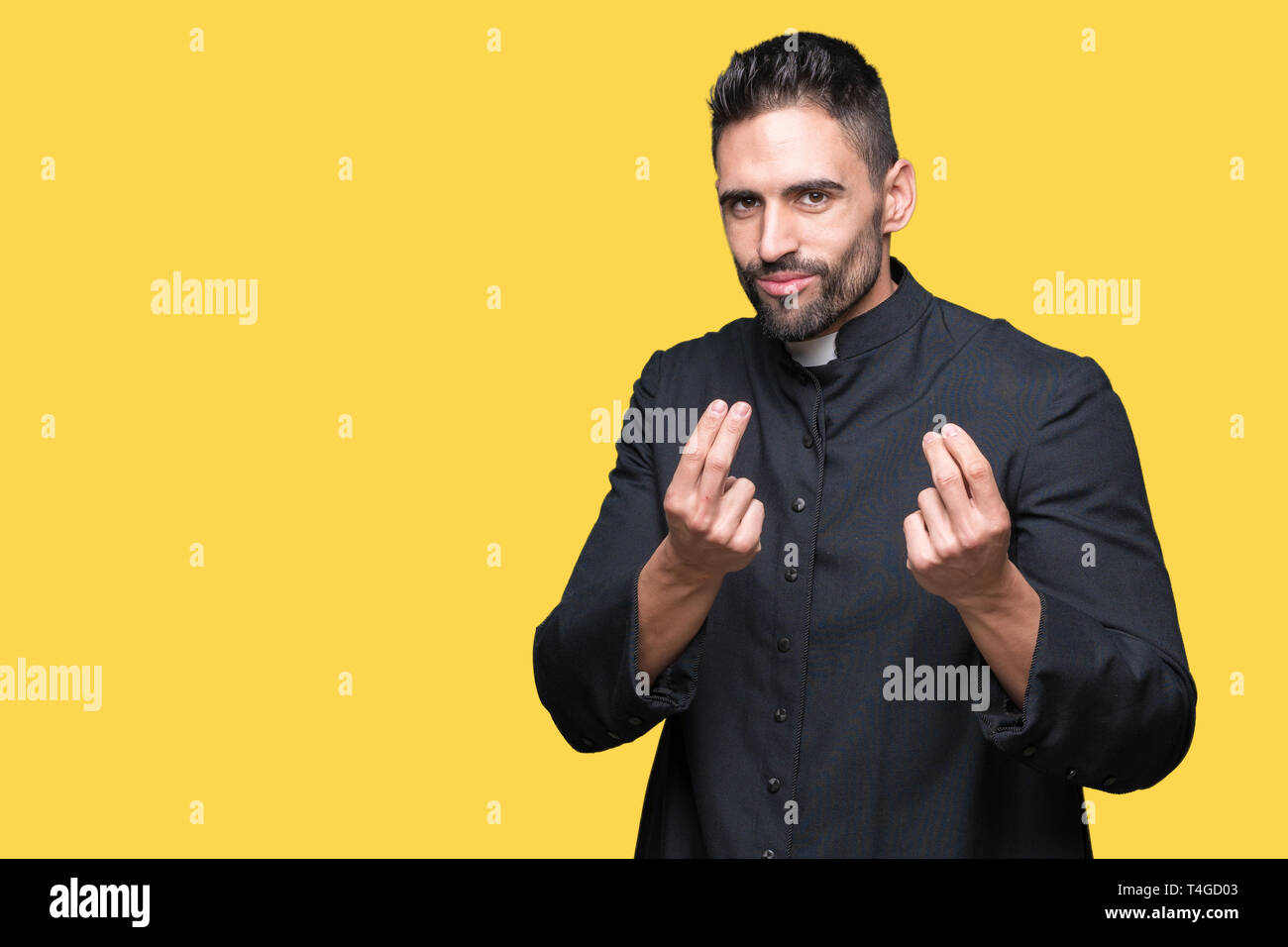 Young Christian priest over isolated background Doing money gesture ...