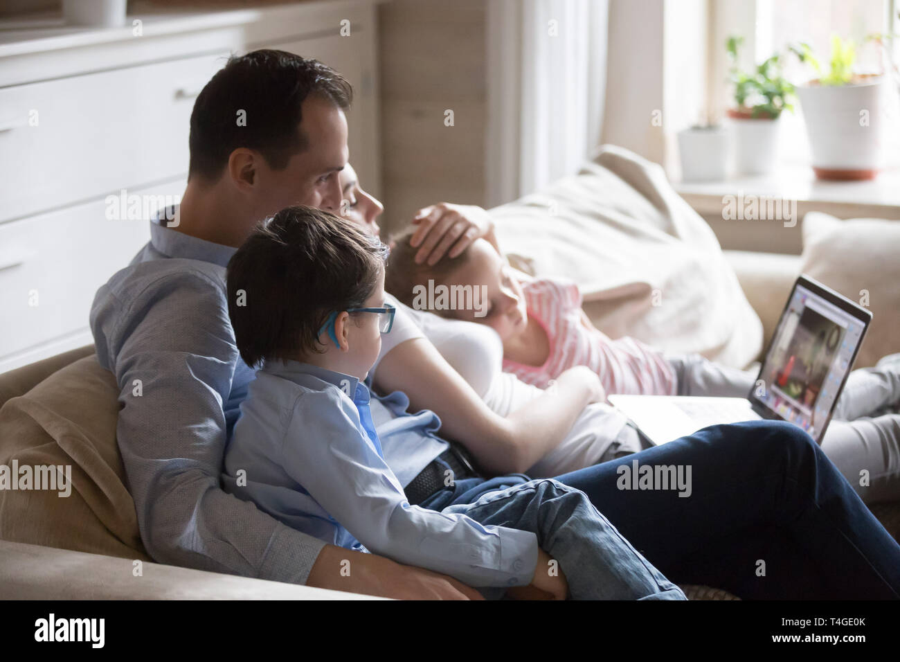 Happy family spending weekend at home watching movie on computer Stock ...