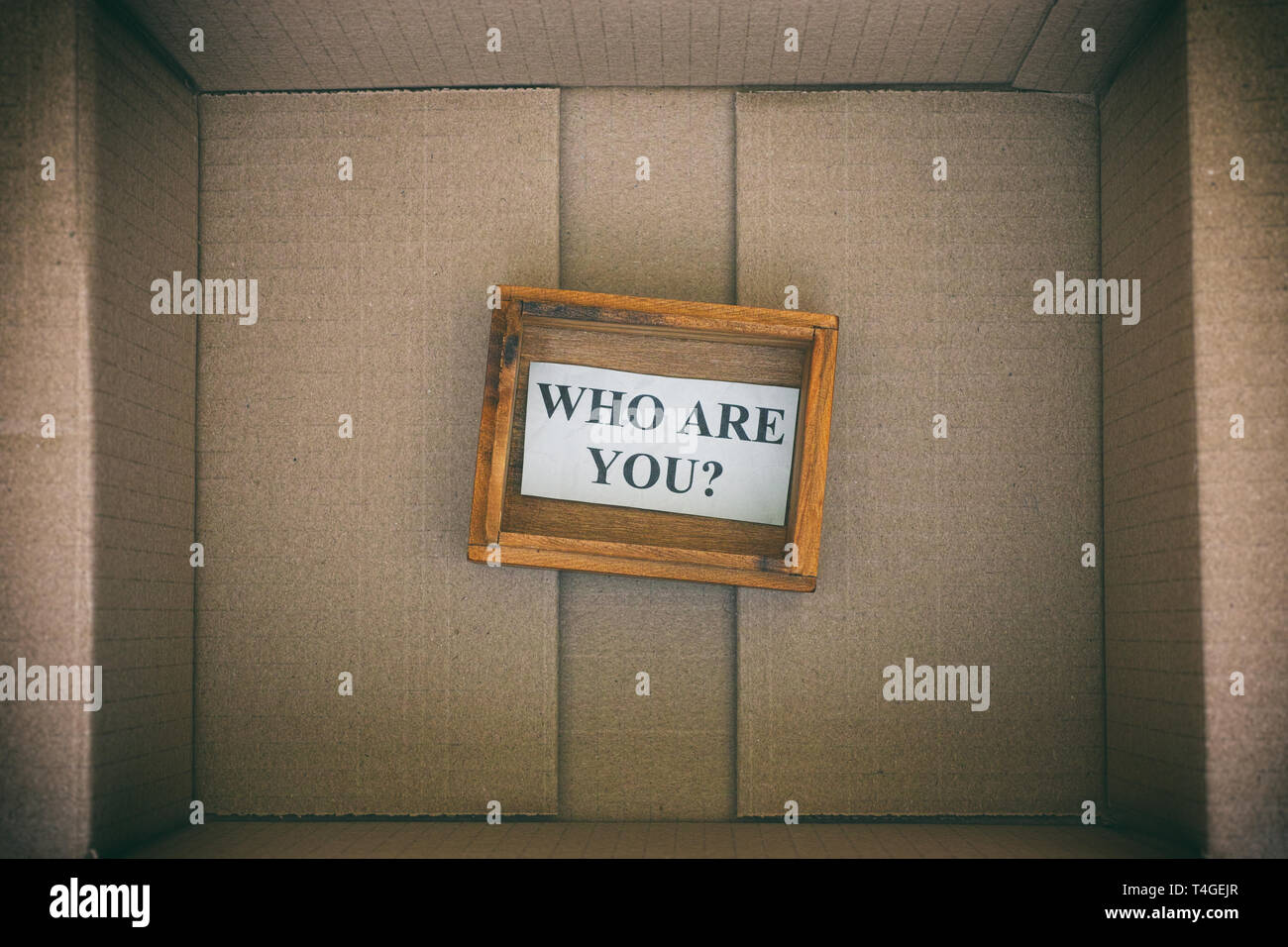 Wooden box with question Who are you inside cardboard box. Concept ...