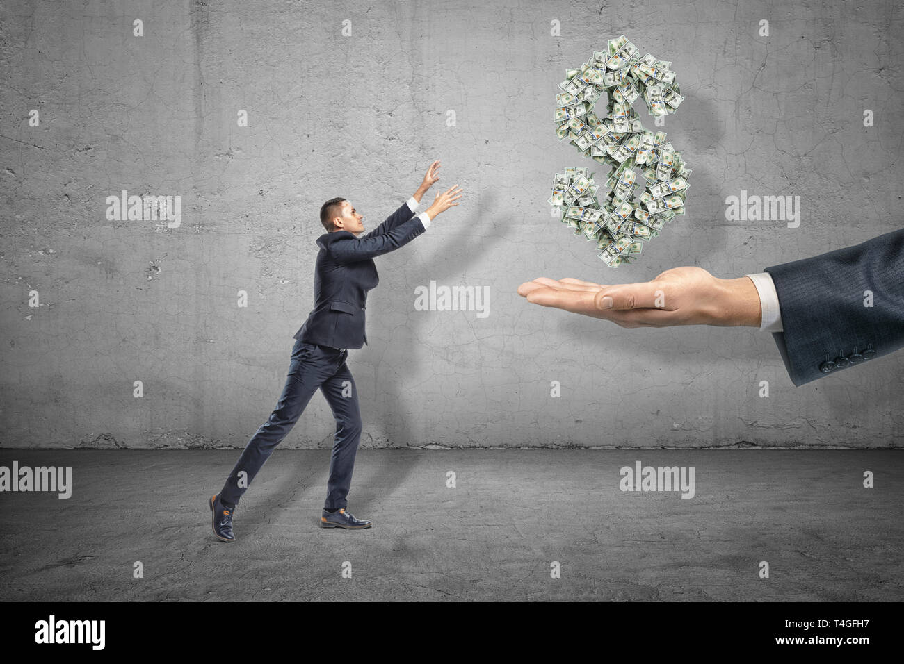 Side view of miniatured businessman holding out hands to grab dollar ...
