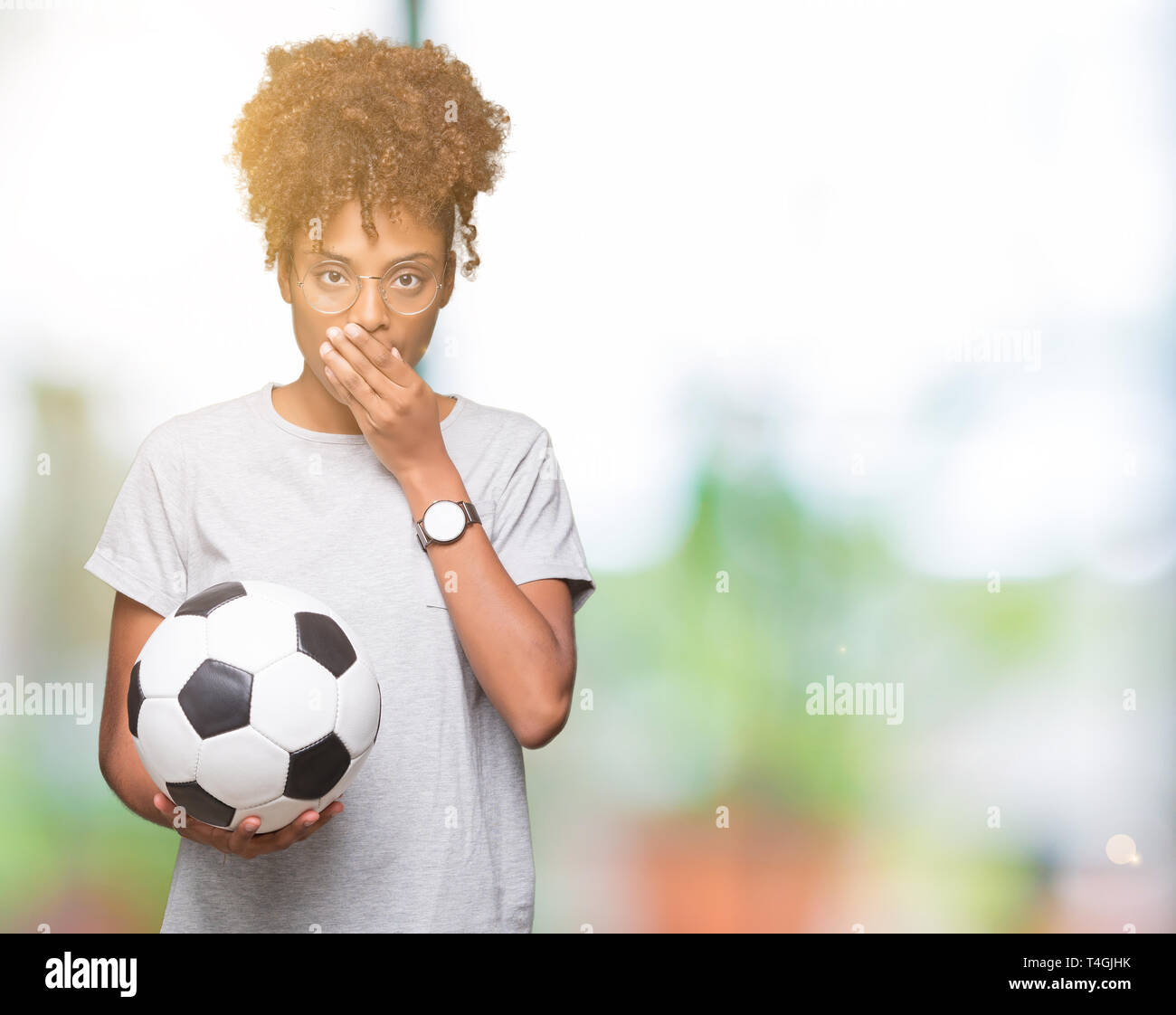 Young african american woman holding soccer football ball over isolated ...