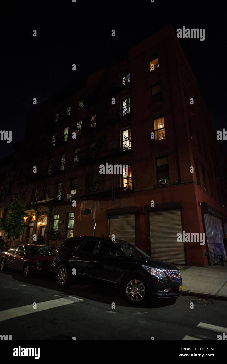 Street with a building with the windows lit at night in Harlem ...
